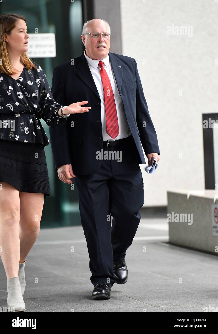 Dr Angus McDonnell (right) leaves the Magistrates Court in Brisbane ...