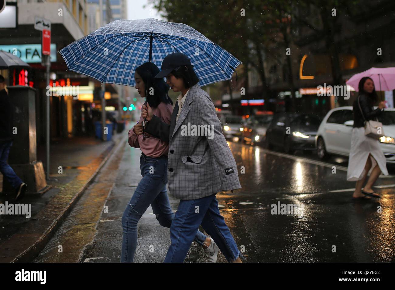 Pedestrians are seen with umbrellas during wet weather in Sydney ...