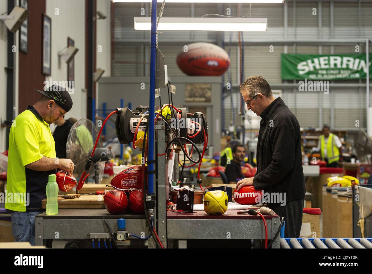 Staff work on the production of Sherrin footballs to be used in the ...