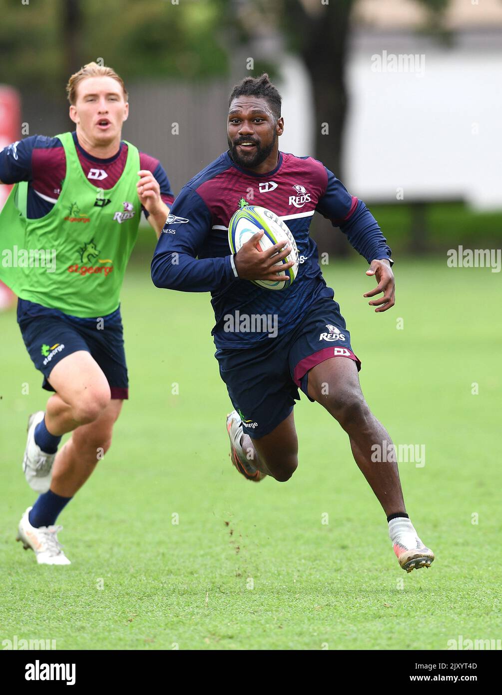 Queensland Reds player Moses Sorovi (right) is chased by Tate McDermott ...