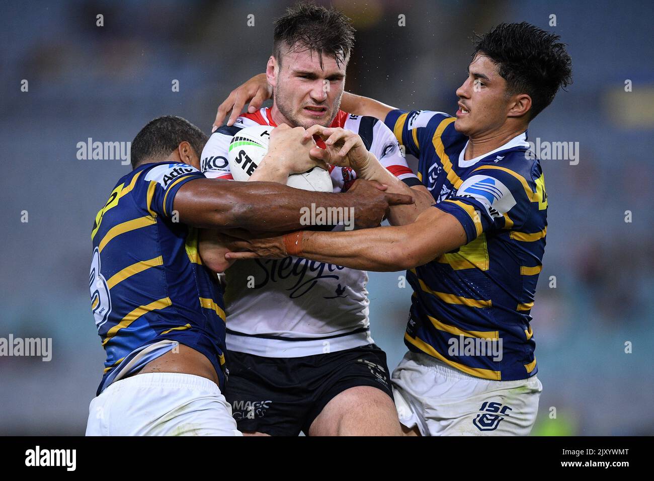 Angus Crichton of the Roosters is tackled by Michael Jennings (left ...