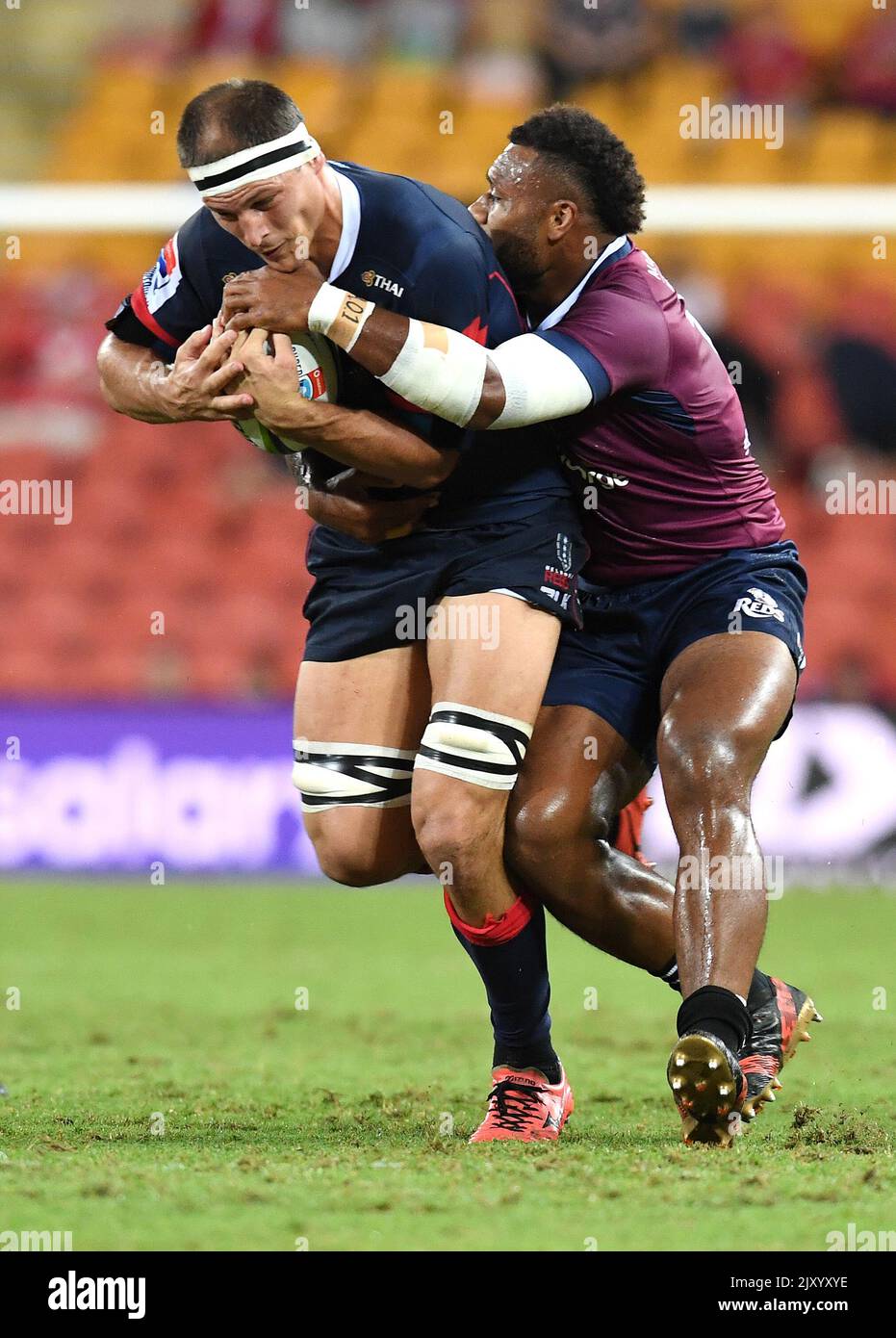Luke Jones of the Rebels (left) is tackled by Samu Kerevi of the Reds ...