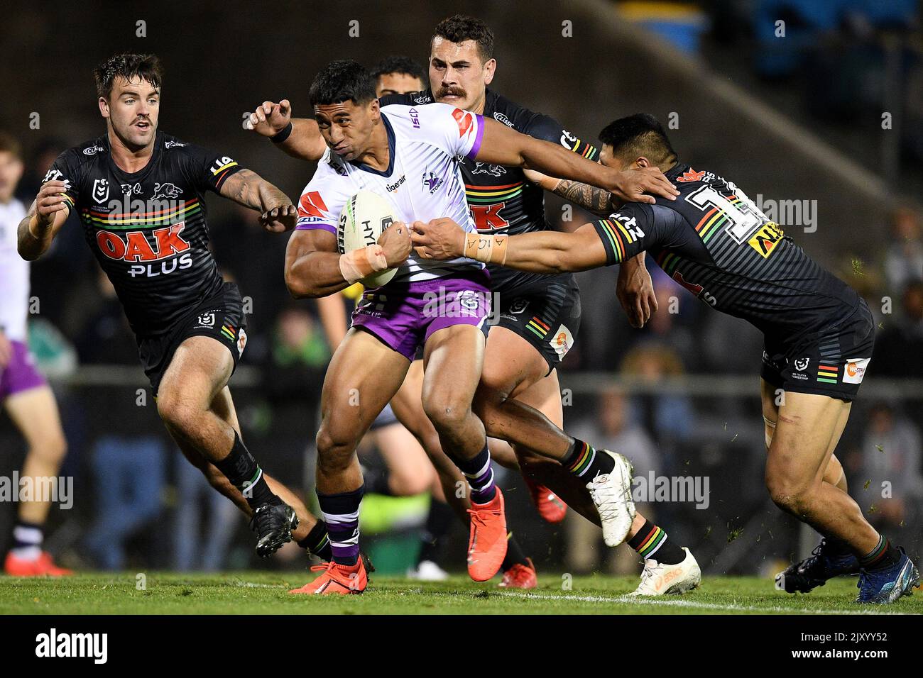 Marion Seve of the Storm evades a tackle by Moses Leota of the Panthers ...