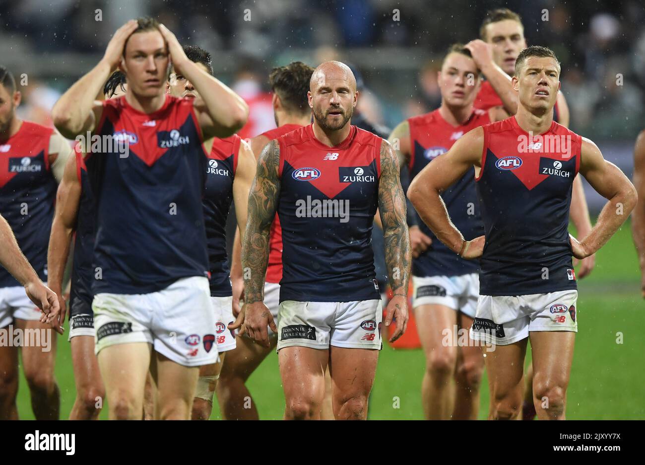 Nathan Jones of the Demons (centre) leads the players from field after ...