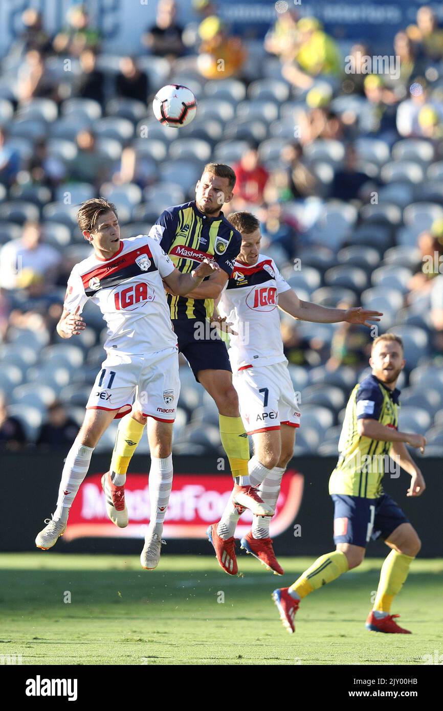 Jordan Murray of the Central Coast Mariners heads the ball and Craig ...