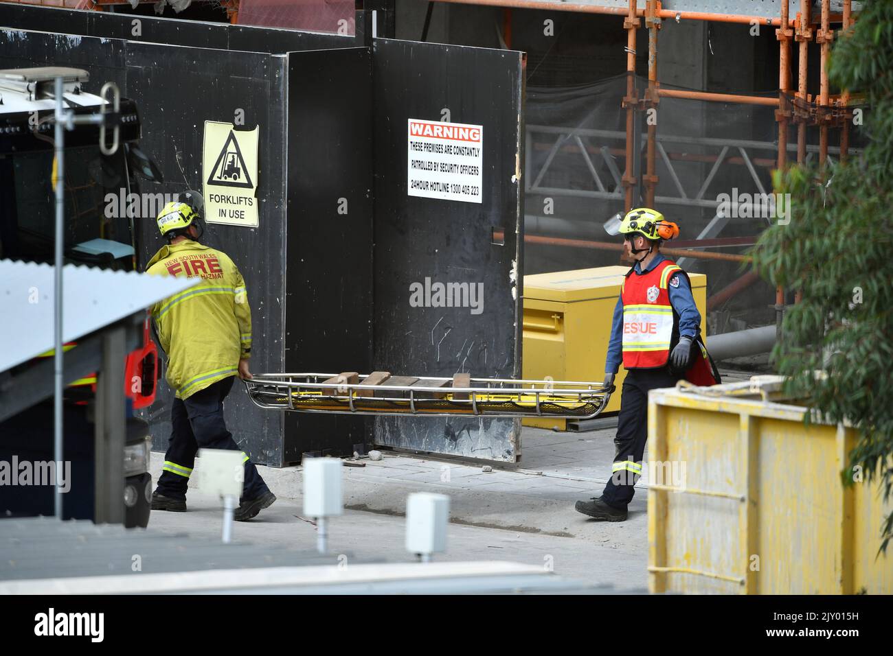 Rescue workers at the scene where a construction worker is trapped ...
