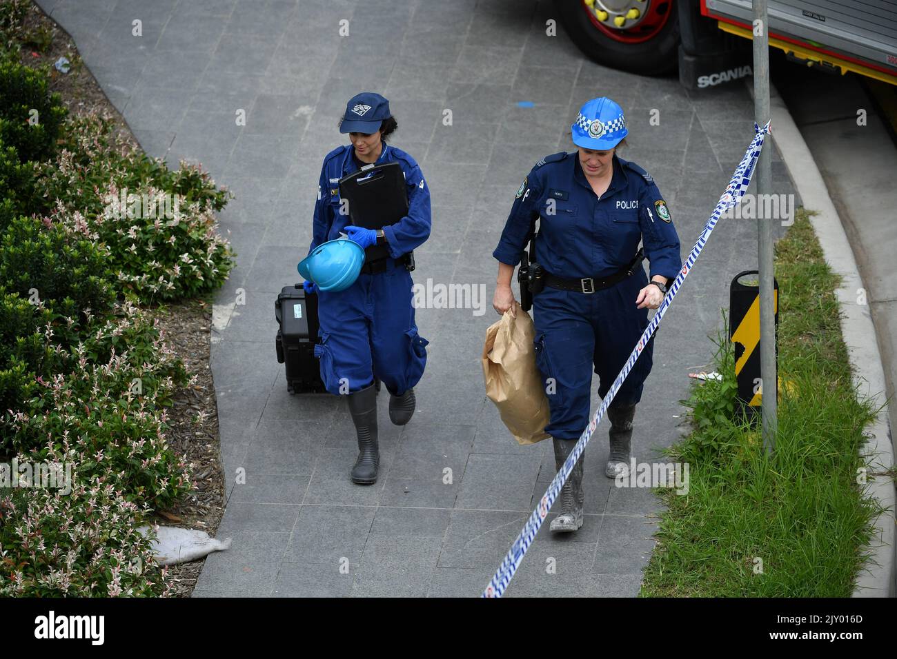 Rescue workers at the scene where a construction worker is trapped ...