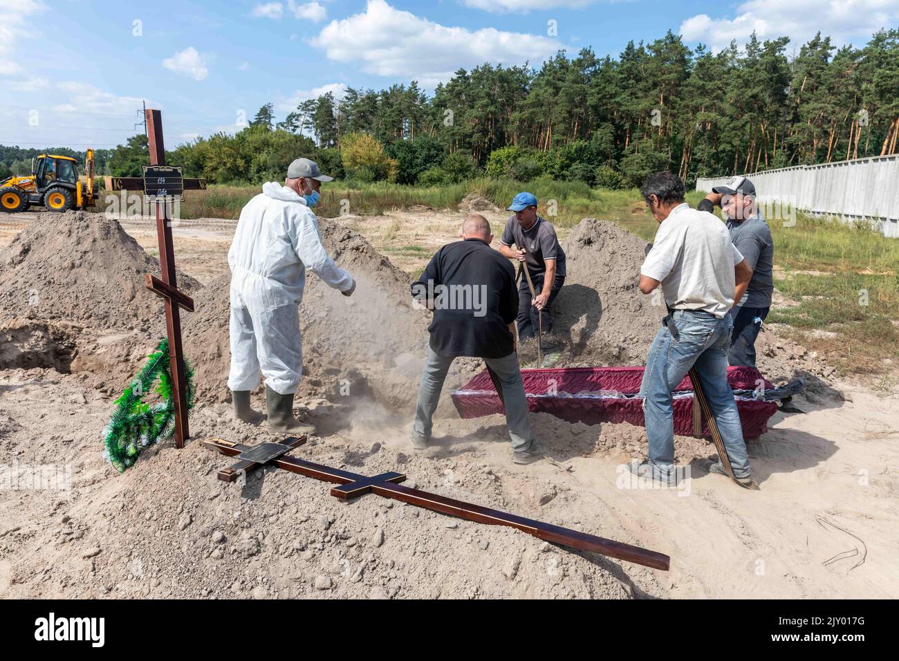 Bucha, Ukraine. 2nd Sep, 2022. A group of men bury unidentified victims ...