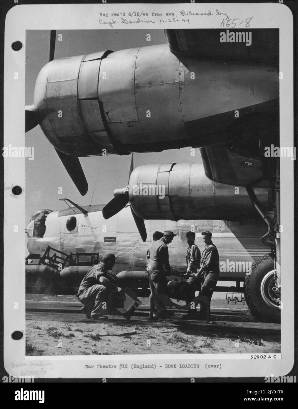 500-pounders are lifted by hand by Ordnance crew from bomb trailer to ...