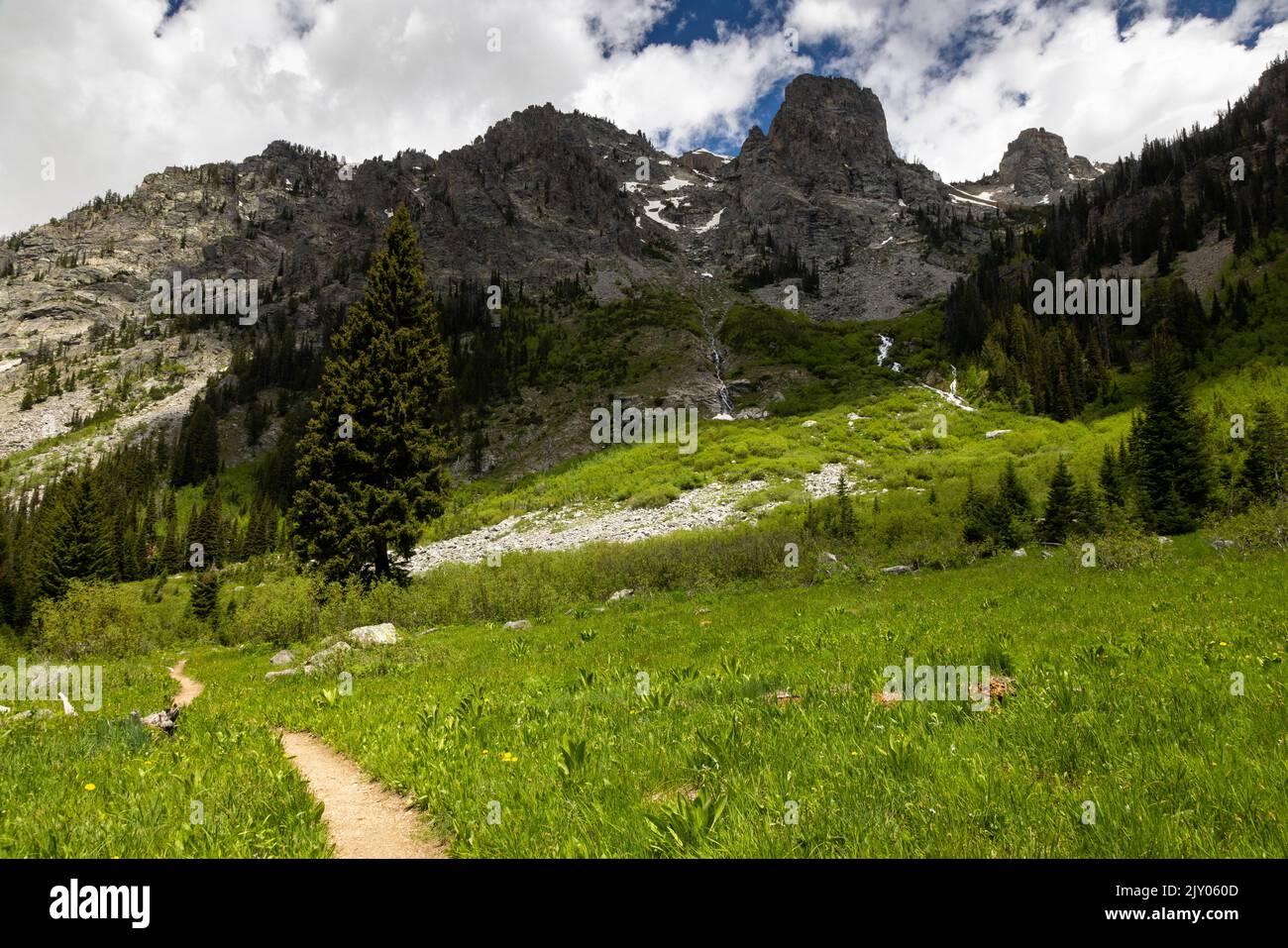 The Death Canyon Trail winding through a meadow below the walls of ...