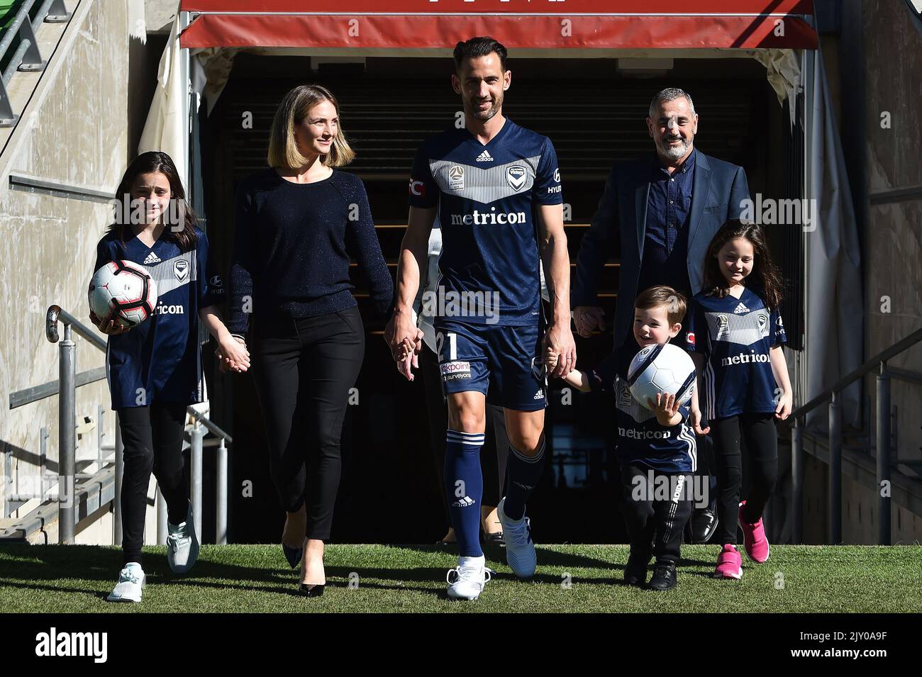 Carl Valeri (centre) and family walk onto the field AAMI Park ...