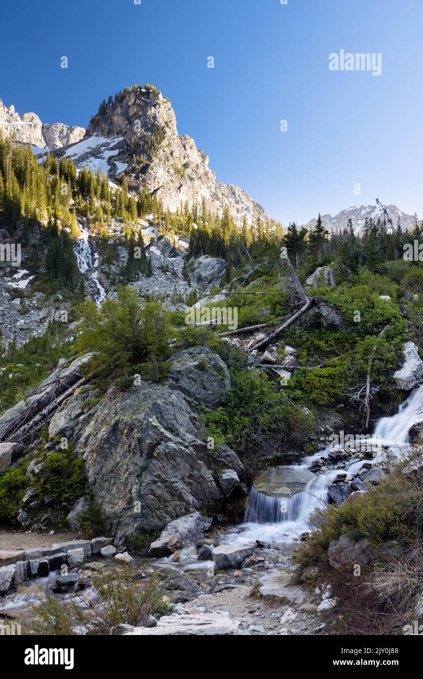 A waterfall pouring over rocks below a peak in Paintbrush Canyon. Grand Teton National Park ...