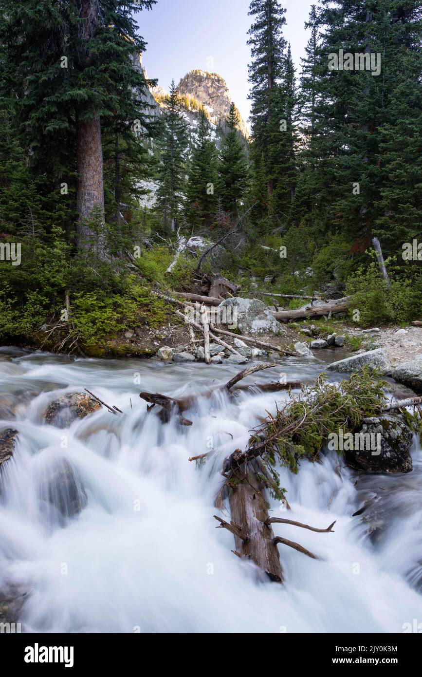 Evening light hitting a tall peak above a crashing waterfall along the Paintbrush Canyon Trail ...