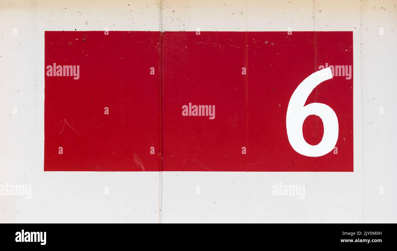 A white number 6 on a red facade Stock Photo - Alamy