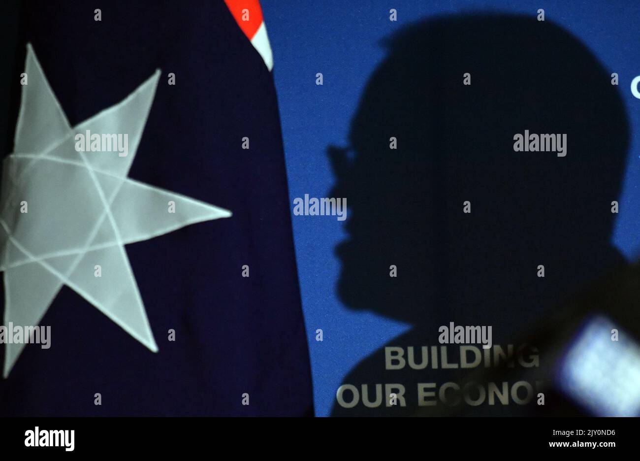 The shadow of Prime Minister Scott Morrison is seen on a backdrop at a ...
