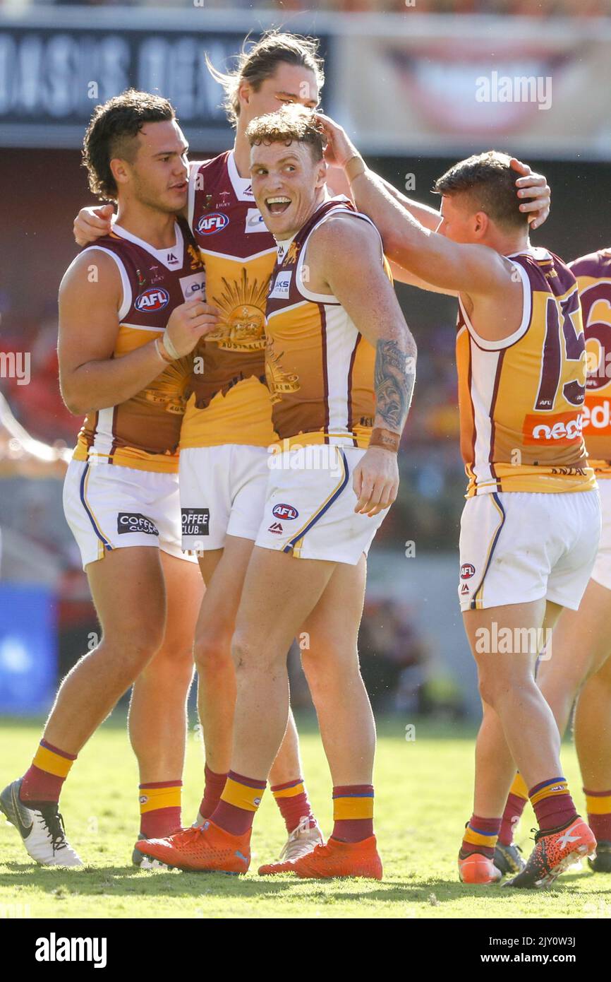 Mitch Robinson of the Lions celebrates with teammates after scoring a ...