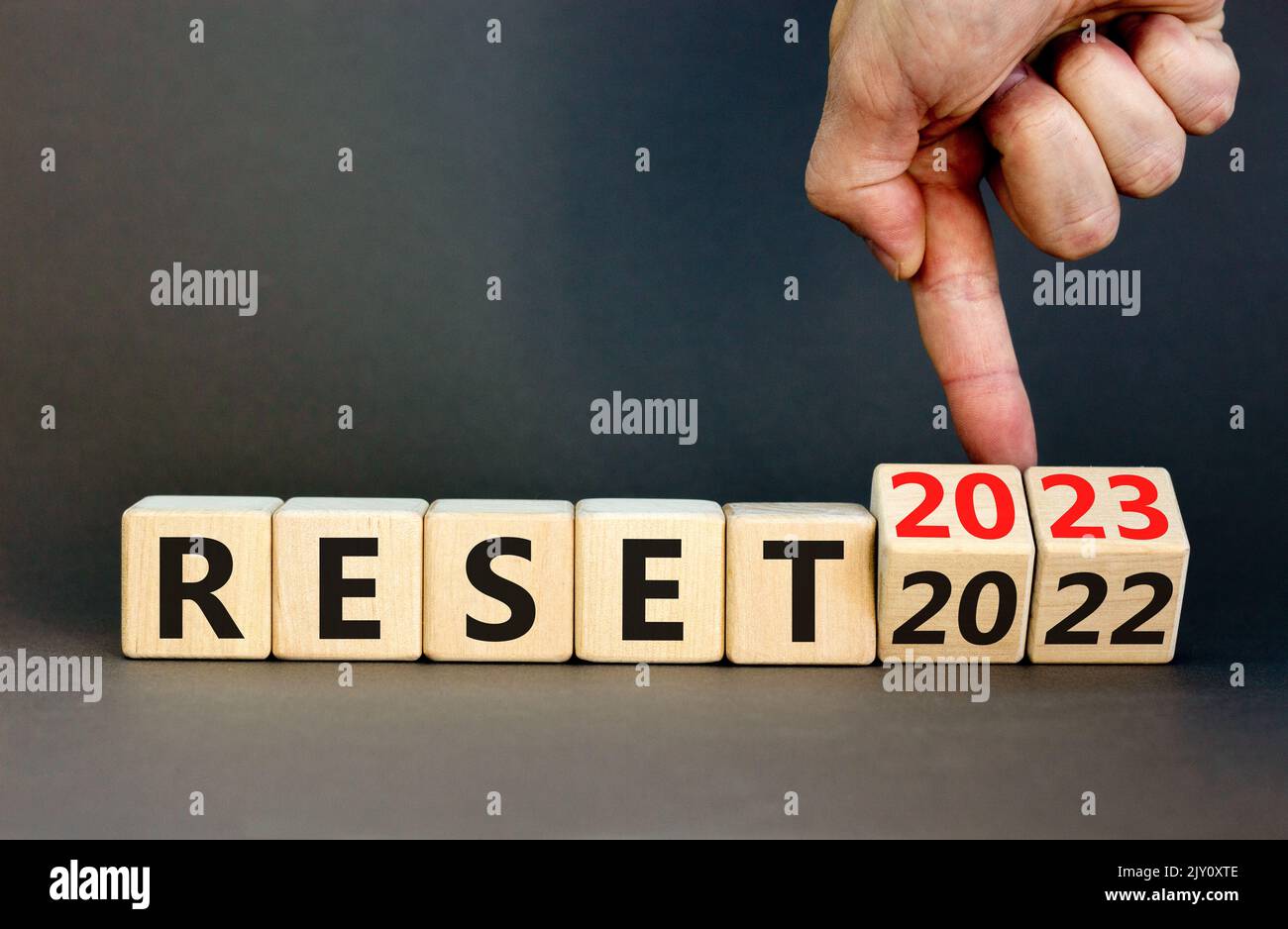 2023 reset new year symbol. Businessman turns a wooden cube and changes ...