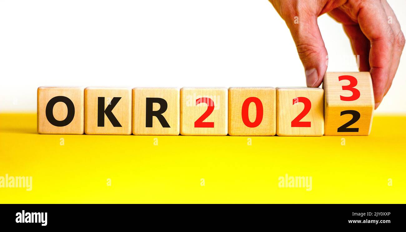 OKR, objectives and key results symbol. Businessman turns cubes with words OKR 2022 and OKR 2023 ...