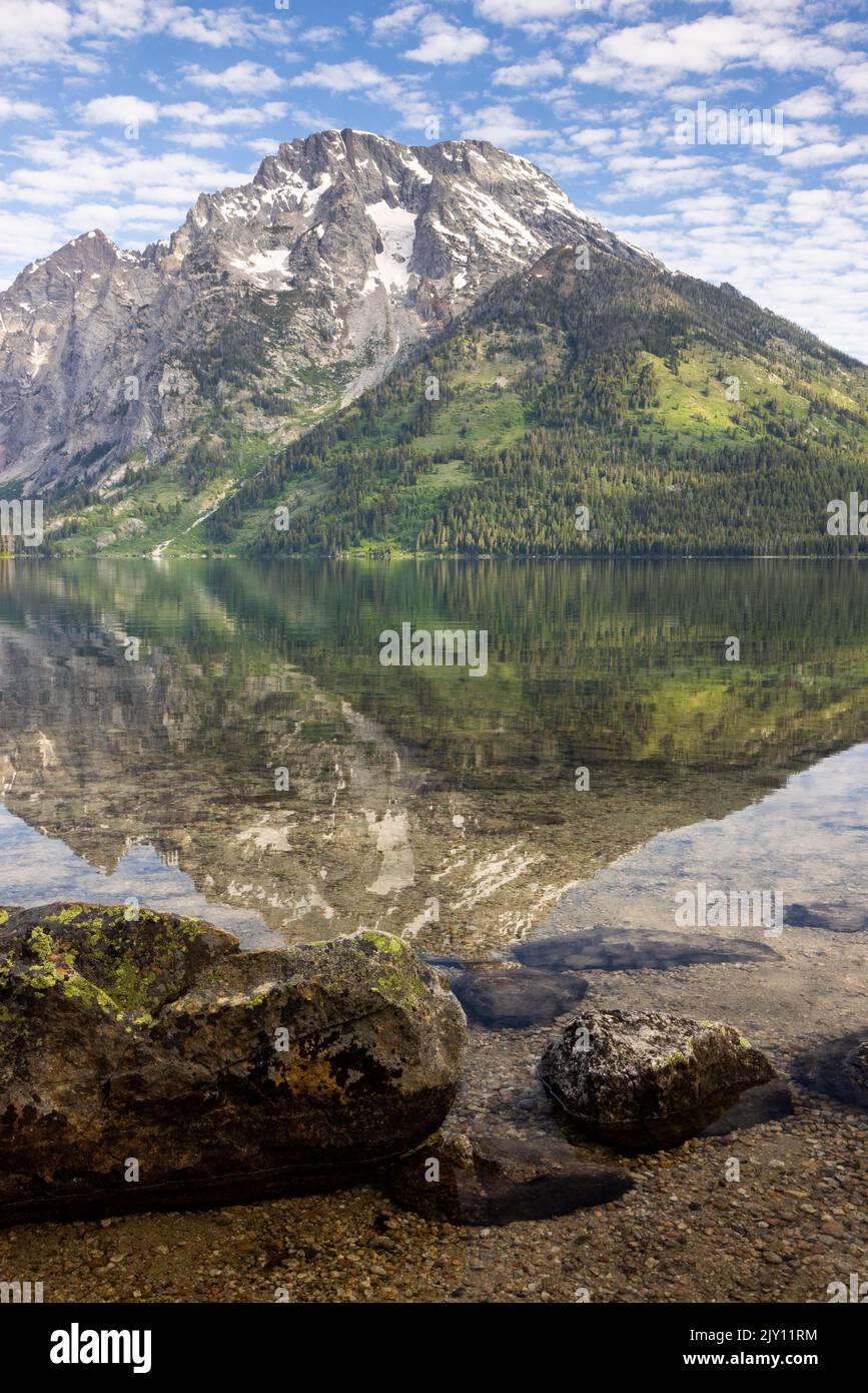 Mount Moran rising high above rocks scattered along the shores of Leigh ...