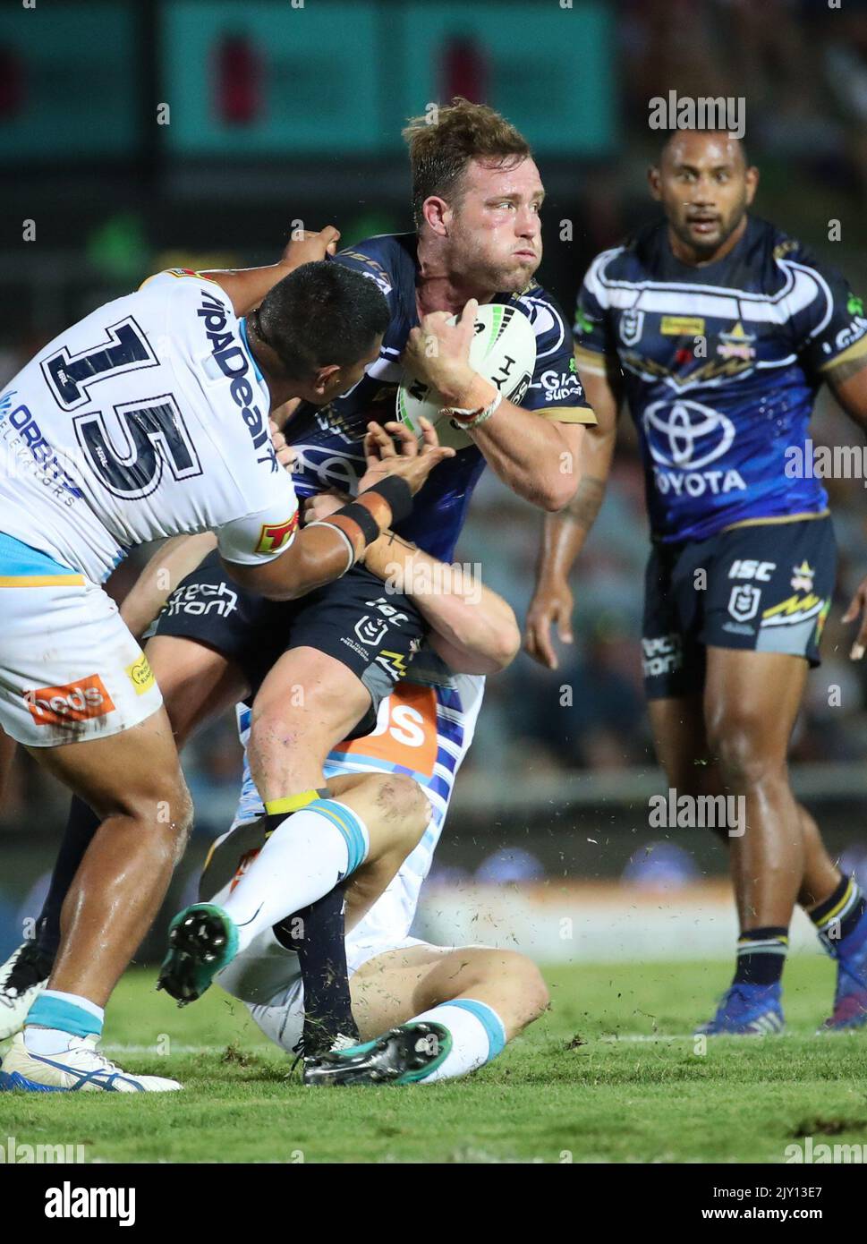 Gavin Cooper of the Cowboys is tackled by Titans defence during the ...