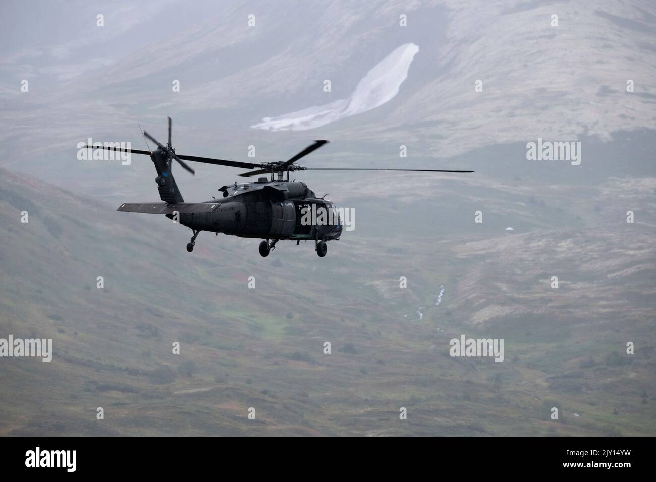 An Alaska Army National Guard UH-60L Black Hawk helicopter passes over ...