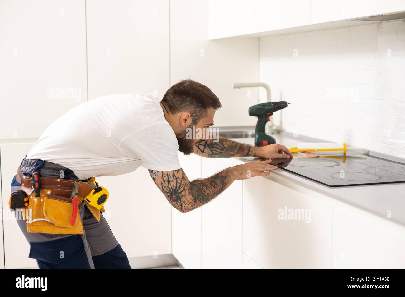 craftsman installs hob in kitchen. Household Appliance Installation ...