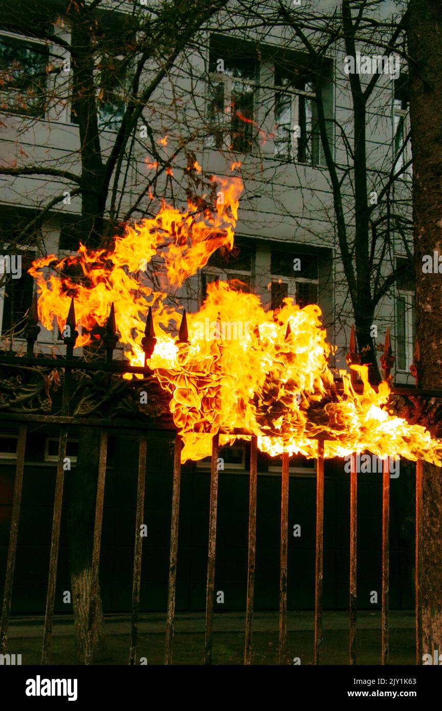 Metal fence on fire. The process of burning old paint on a metal ...