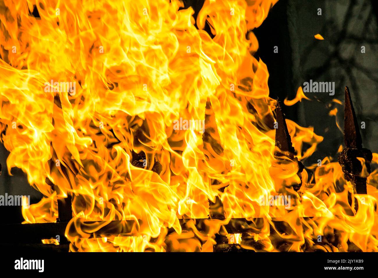 Metal fence on fire. The process of burning old paint on a metal ...