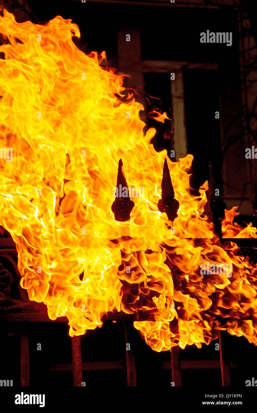 Metal fence on fire. The process of burning old paint on a metal ...