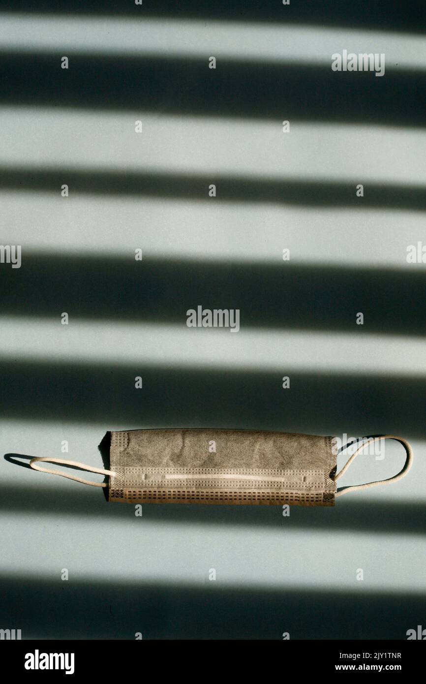 Protective medical face mask on light and shadow with blue background ...