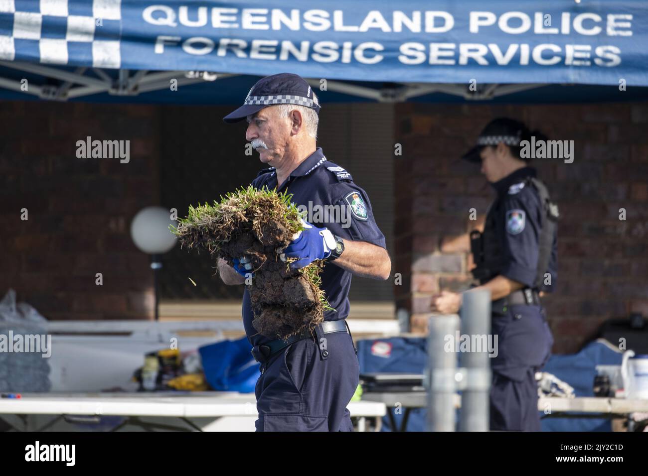 Police investigators are seen digging up a Bracken Ridge home in ...