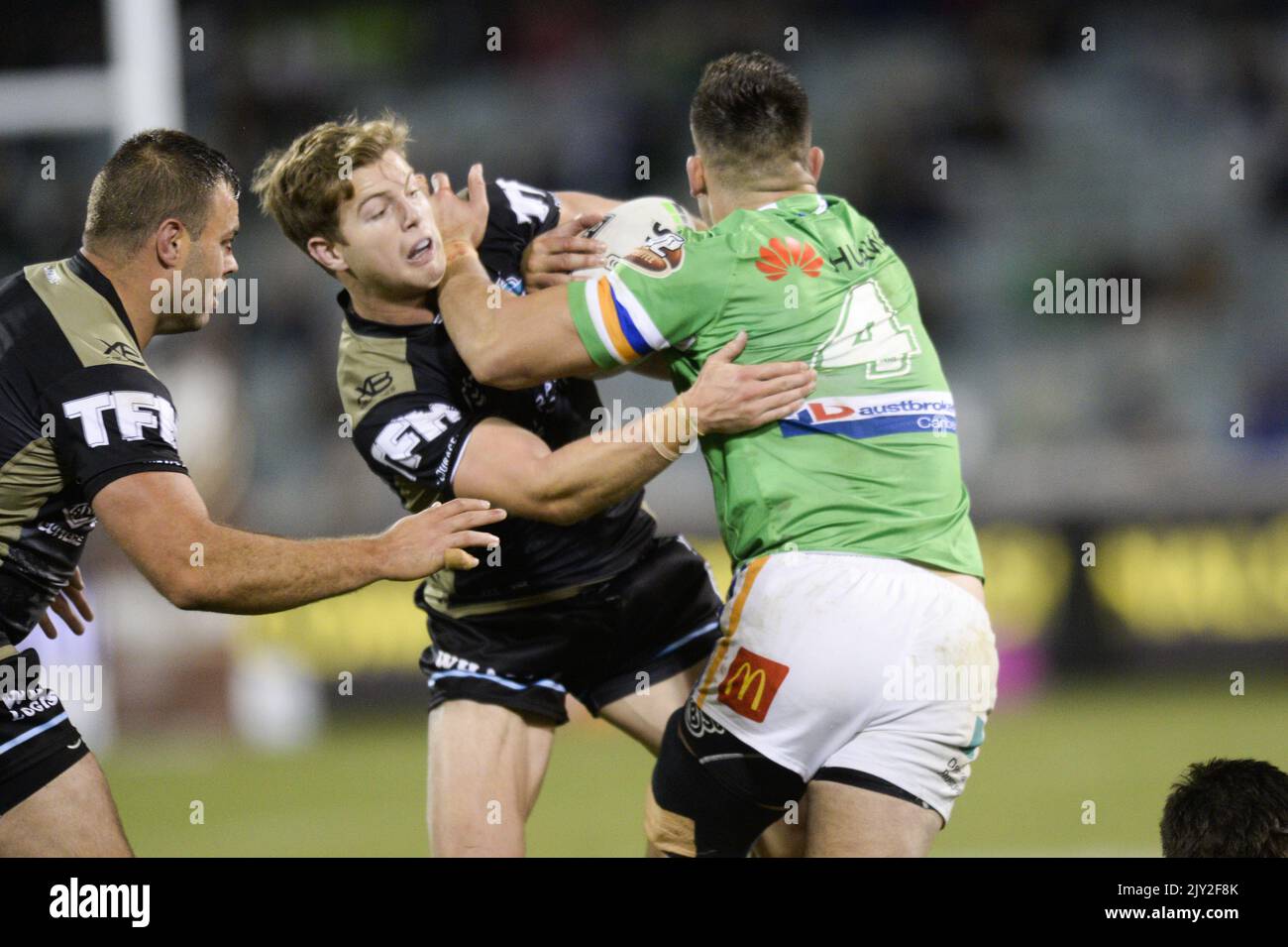 Nick Cotric of the Raiders is tackled by Blayke Brailey of the Sharks ...