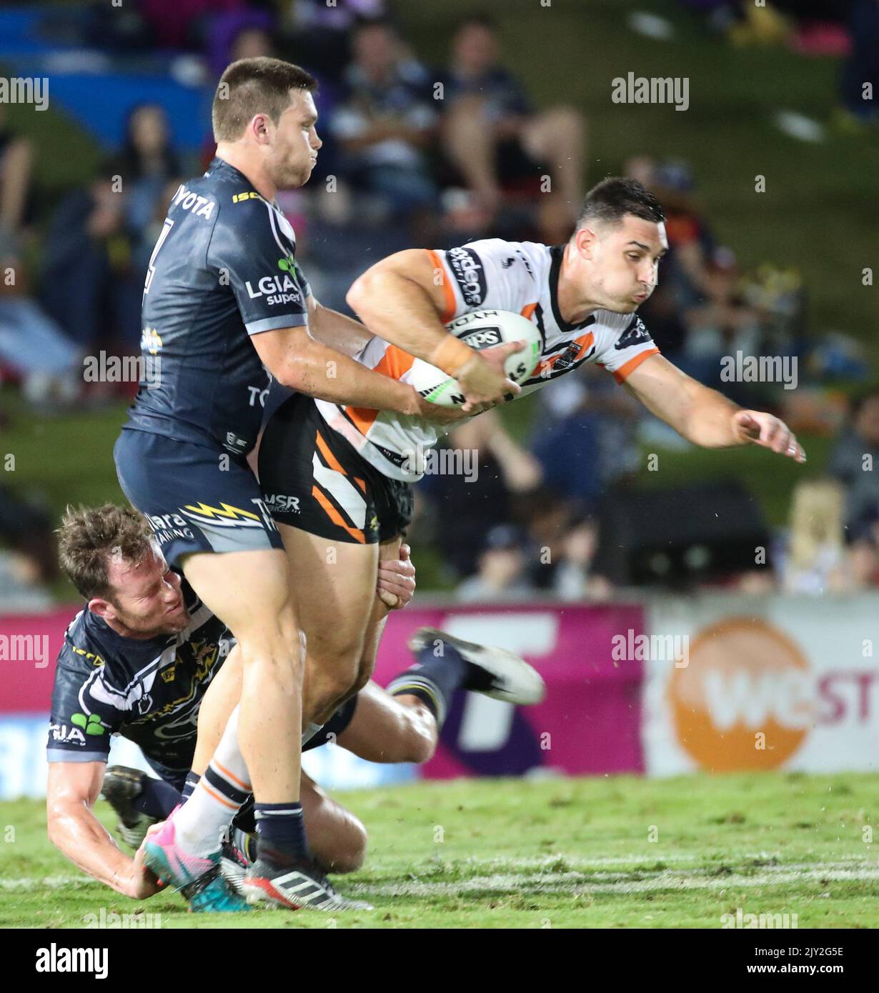 Ryan Matterson of the Tigers is tackled by Gavin Cooper of the Cowboys ...