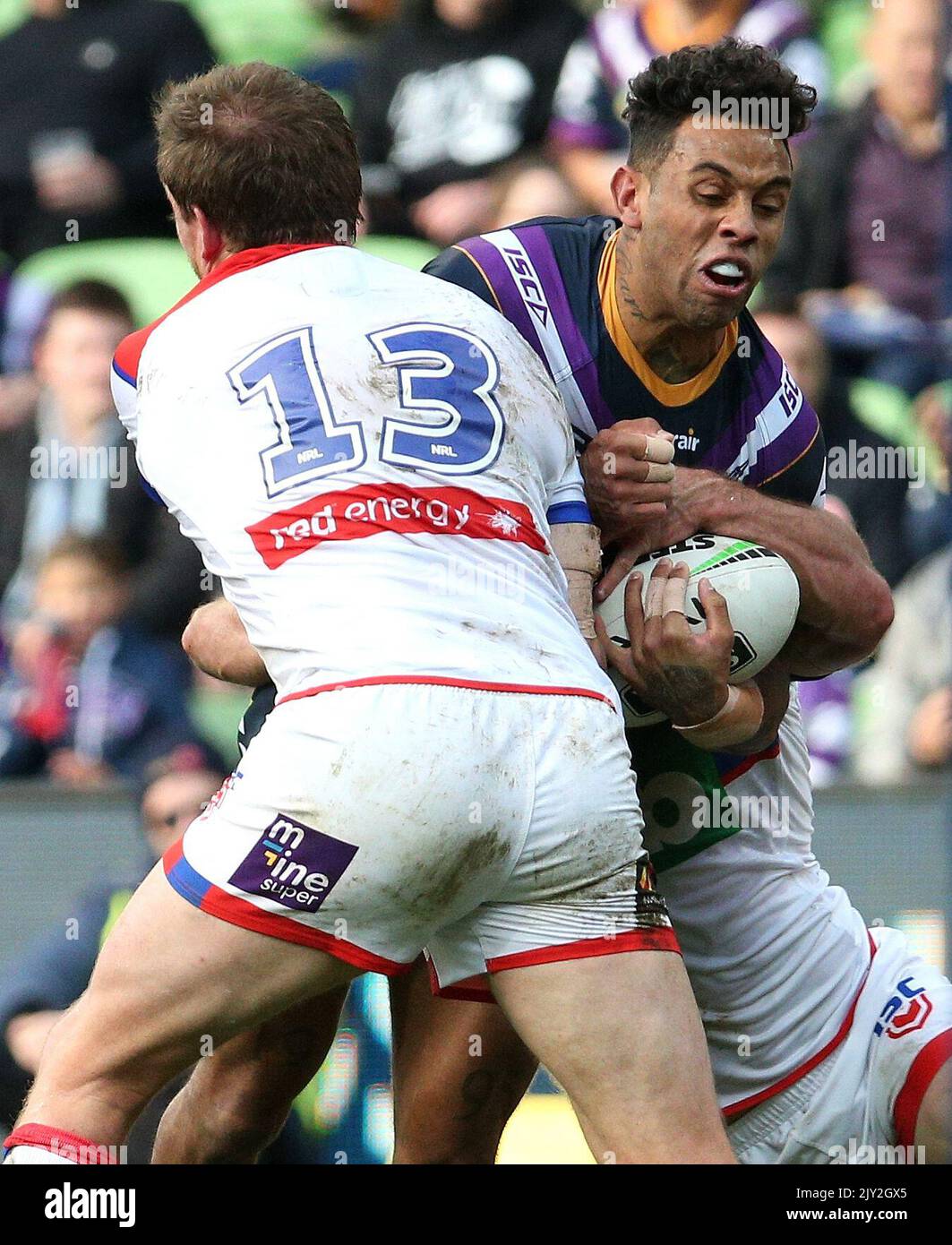 Josh Addo-Carr of the Storm is tackled by Tim Glasby of the Knights ...