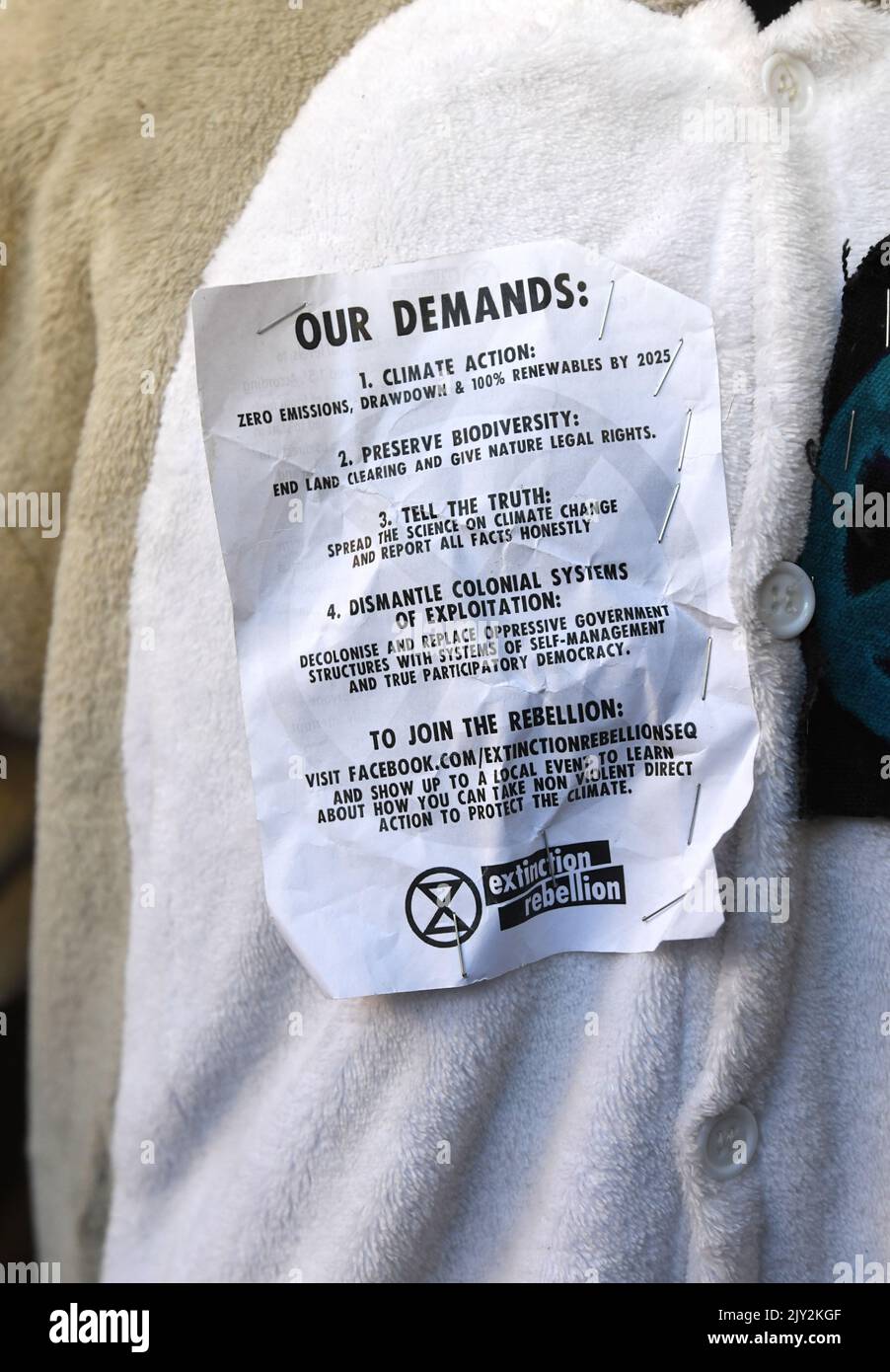 A list of demands is pinned to the outfit worn by Environmental ...