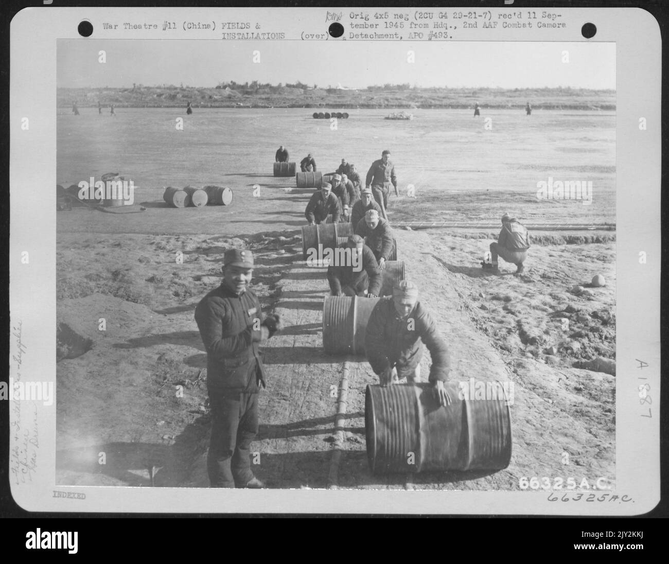 Chinese Rolling Gas Drums Up A Ramp To Storage Tanks Stock Photo - Alamy