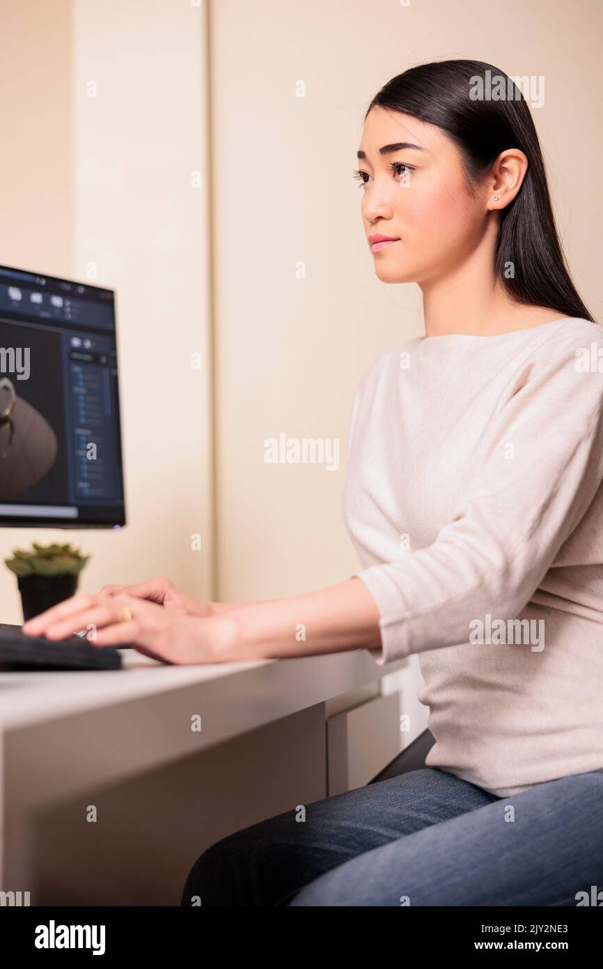 Female technician working on gears engineering, using technical software to manufacture machine ...