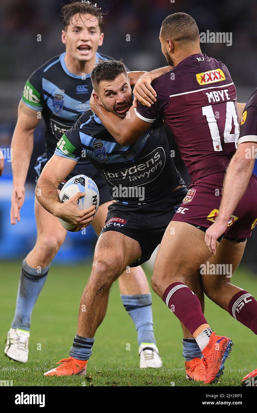 James Tedesco of the Blues is tackled by Moses Mbye of the Maroons ...