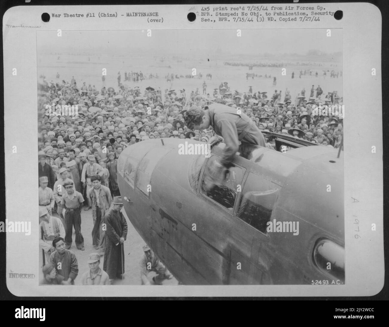 Coolie laborers curiously watch Cpl. James More, 20th Bomber Command ...