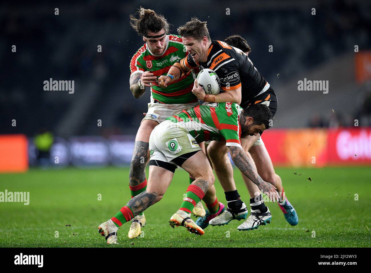 Chris Lawrence of the Tigers is tackled by Ethan Lowe (left) and Adam ...