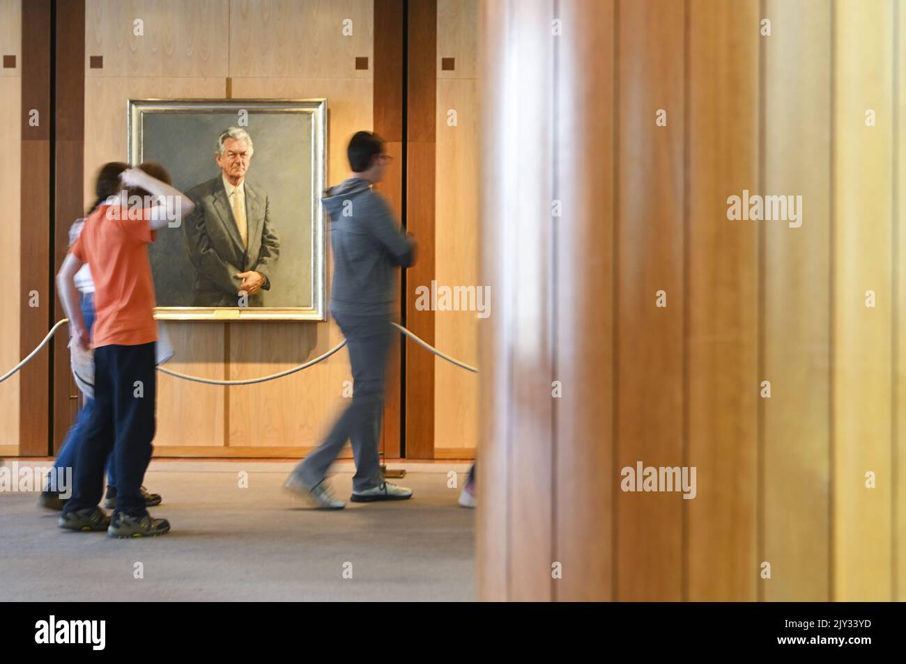Visitors take a look at the official portrait of the late former ...