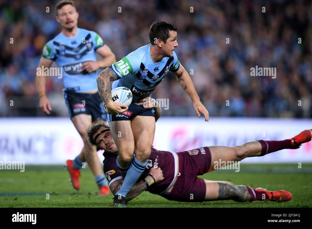 Mitchell Pearce of the Blues is tackled by Ethan Lowe of the Maroons ...