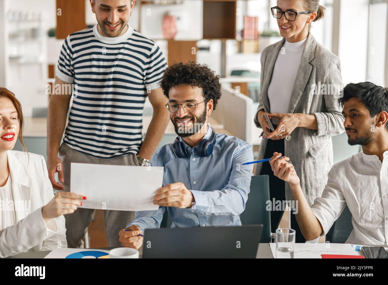 Happy coworkers cooperating and working together at office meeting ...