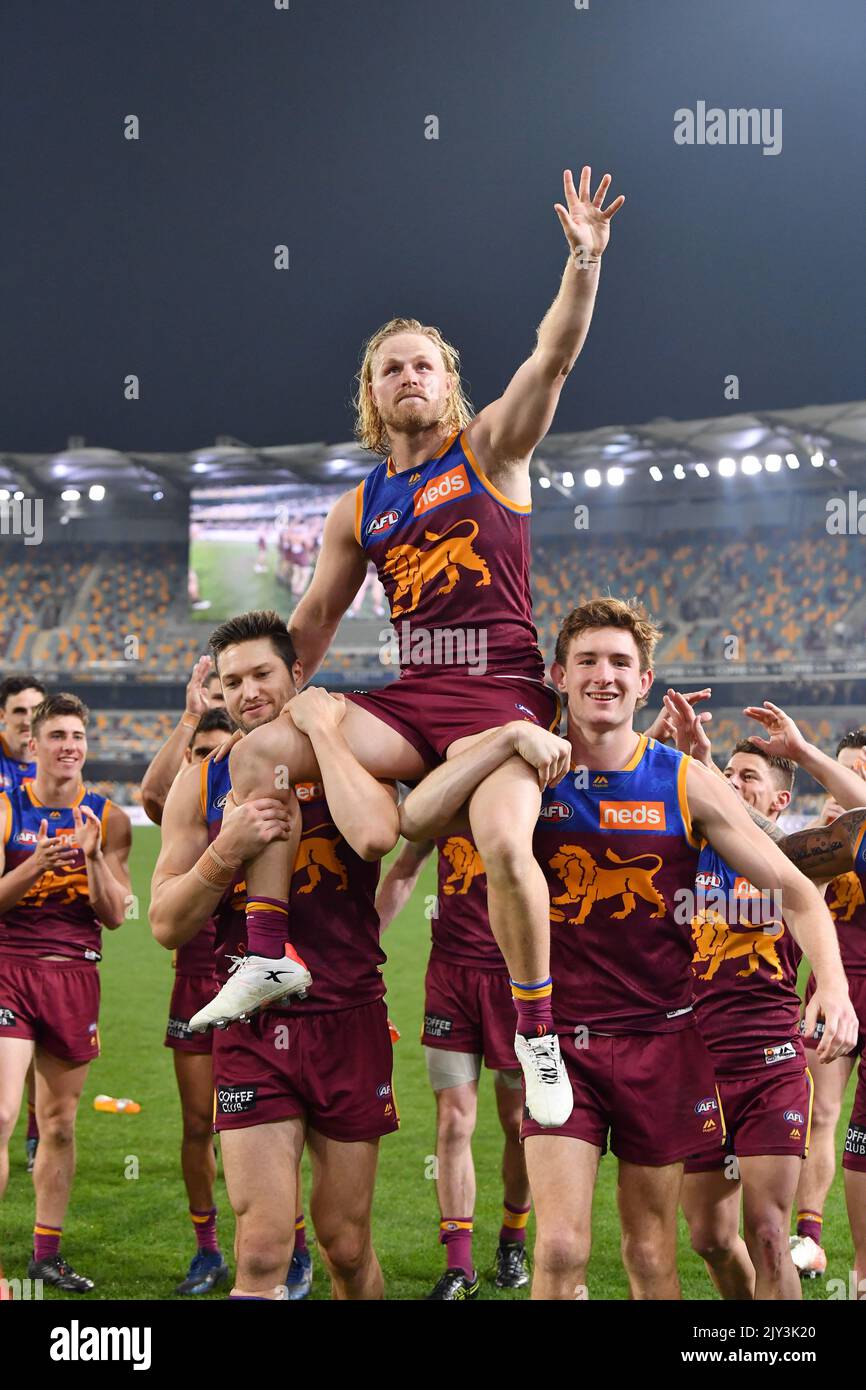 Daniel Rich of the Lions is chaired off by team mates Stefan Martin ...