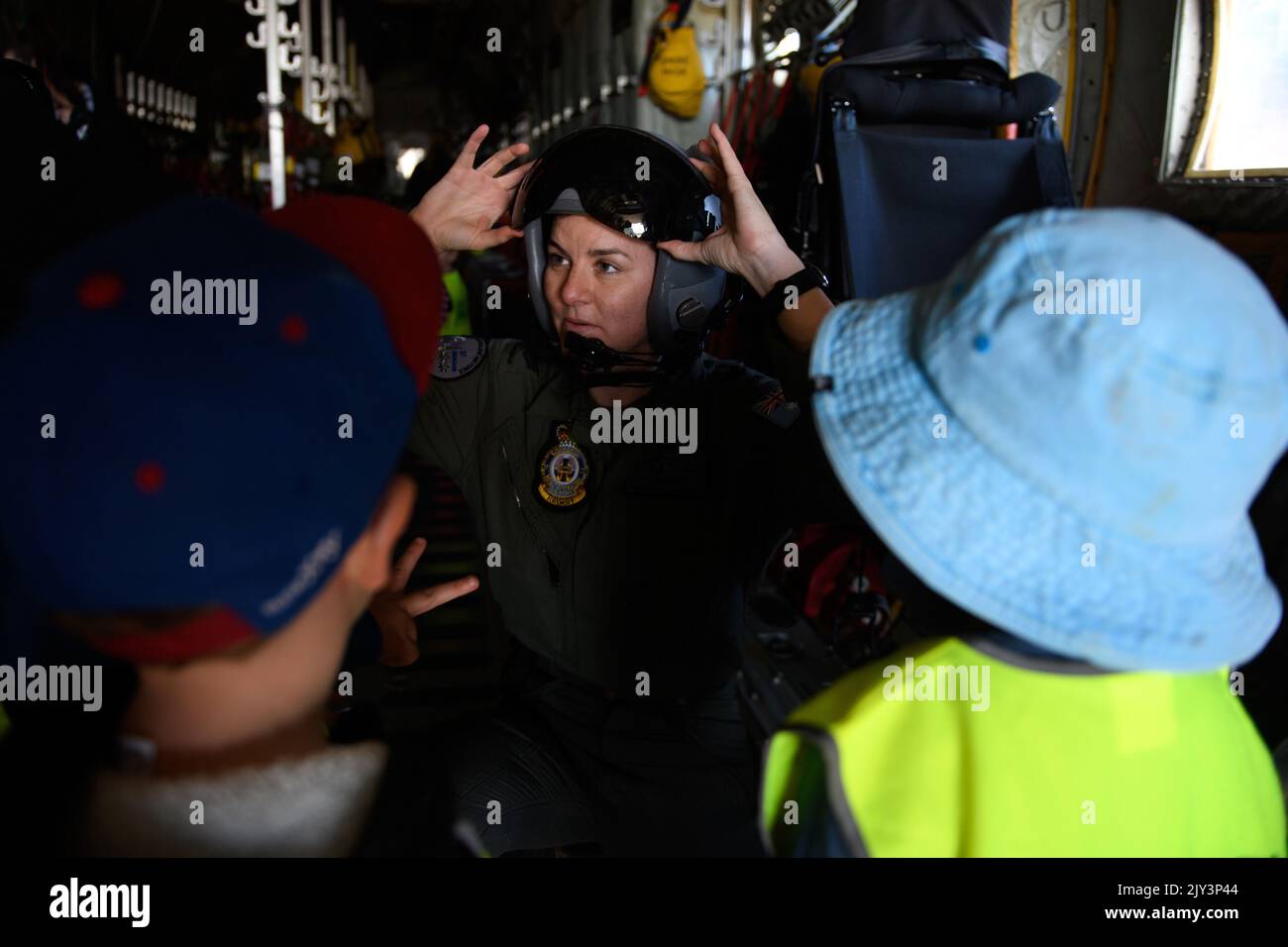 Local children are shown around a Royal Australian Air Force C-130J ...