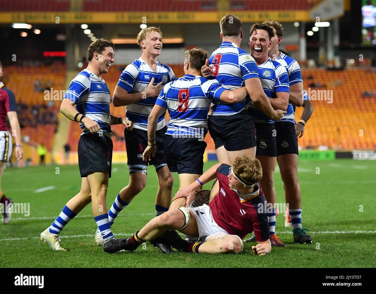 Harrison Vella (centre) of Nudgee College celebrates scoring a try with ...
