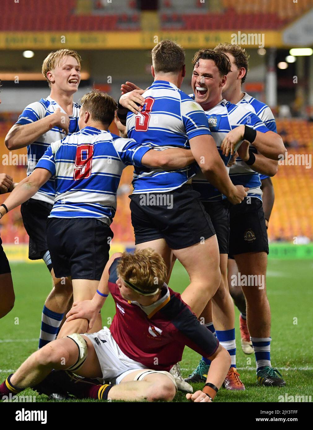 Harrison Vella (centre) of Nudgee College celebrates scoring a try with ...