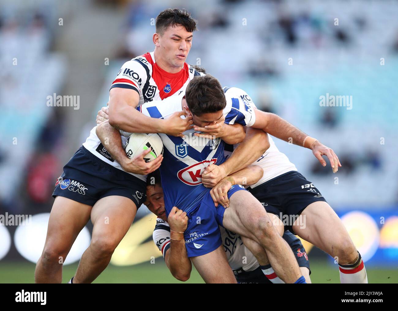 Nicholas Meaney of the Bulldogs is tackled by the Roosters defence ...