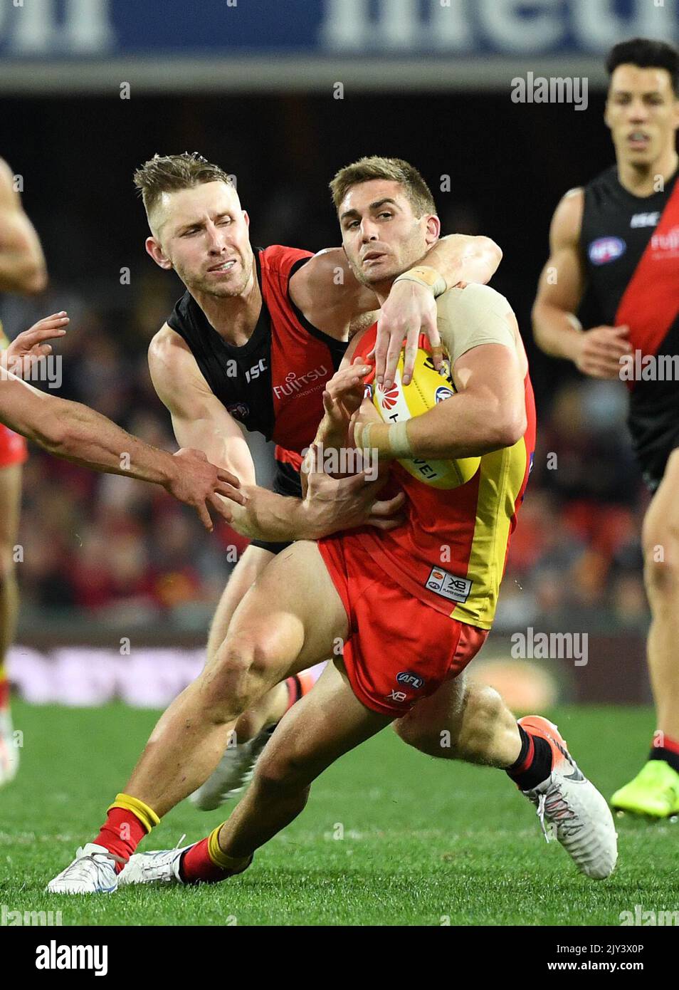Shaun McKernan of the Bombers tackles Anthony Miles of the Suns during ...