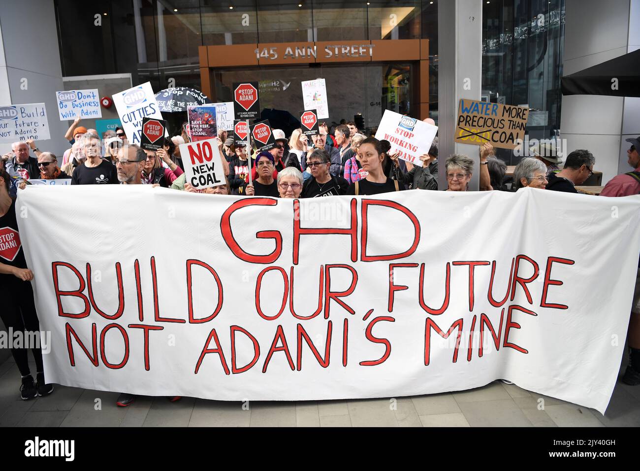Anti-Adani protesters hold placards outside the offices of engineering ...